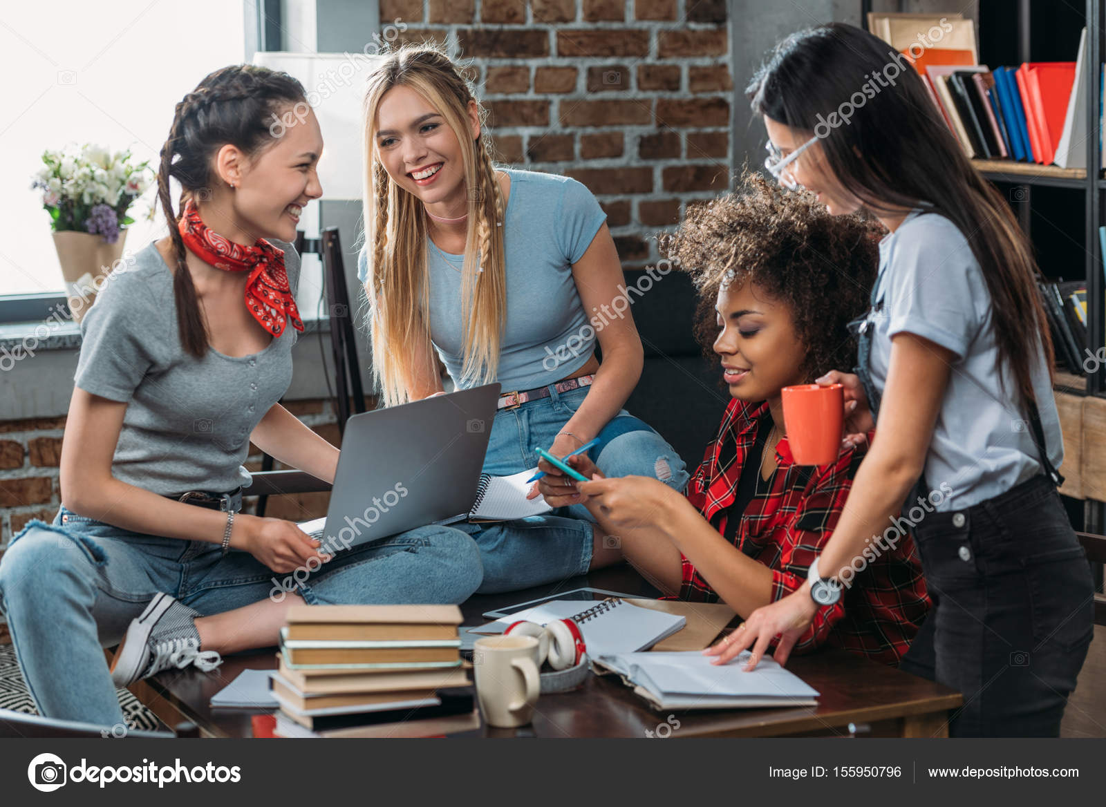 Beautiful smiling young classmates studying together with books and ...