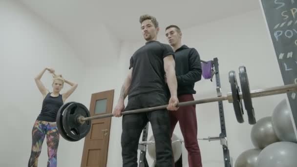 Corporate man in his first day at the gym lifting dumbbells and working ...