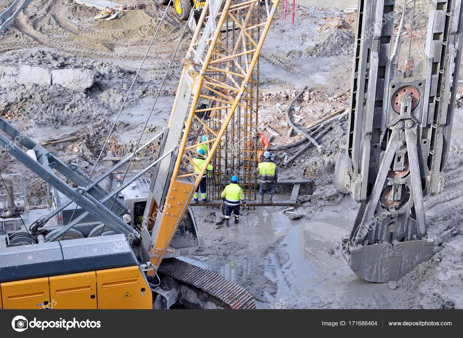 Worker working at pile driver works to set precast concrete piles in a ...