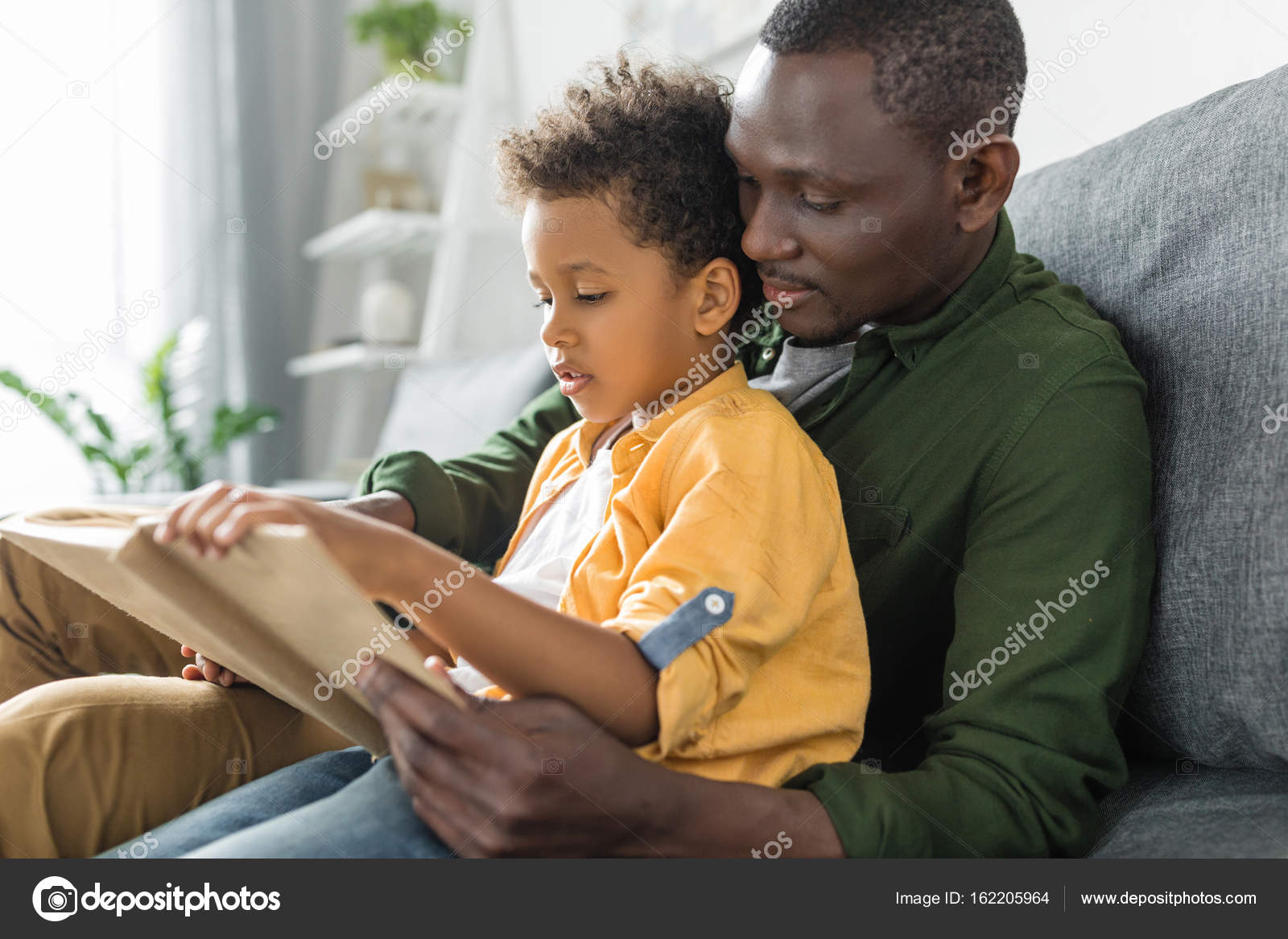 Father and son reading book together — Stock Photo © SarkisSeysian ...