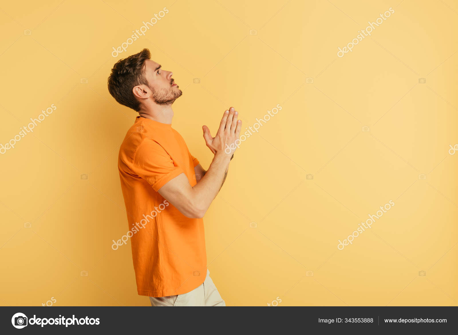 Side View Serious Young Man Looking While Praying Yellow Background ...