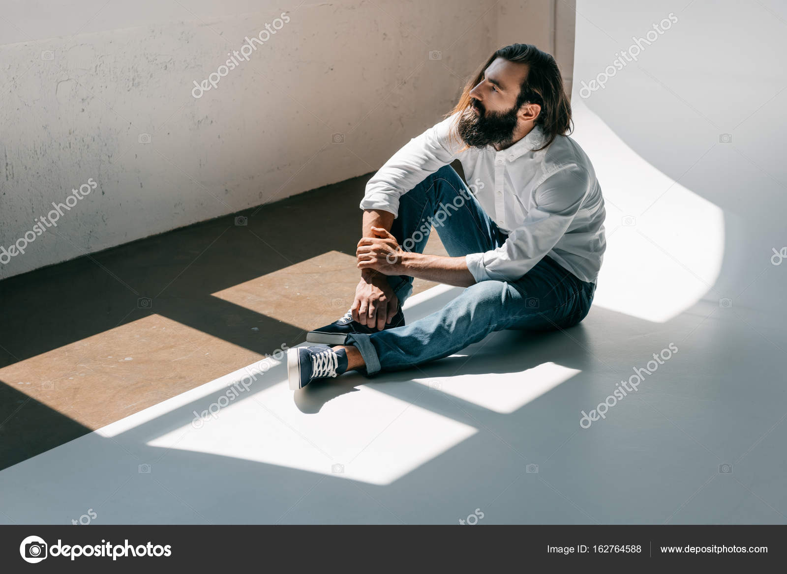 Handsome man sitting on floor — Free Stock Photo © HelenKayda #162764588
