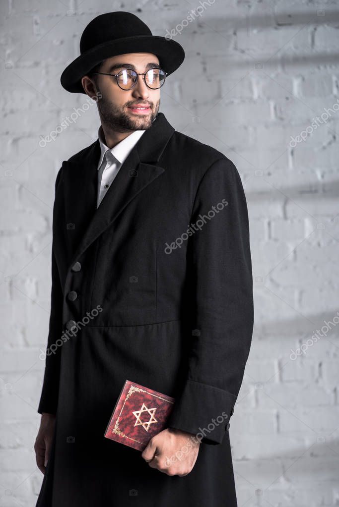 hombre judío guapo y sonriente en vasos que sostienen tanakh 2022