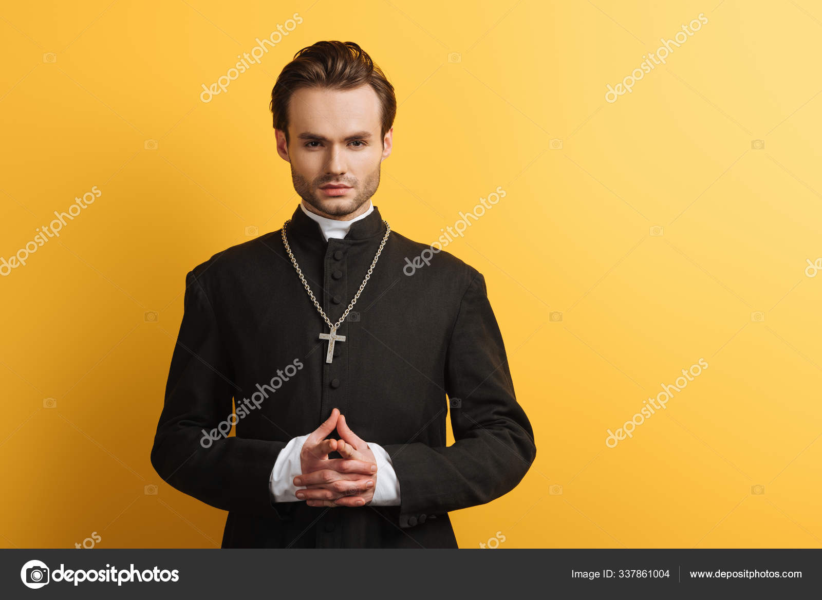 Serious Catholic Priest Standing Clenched Hands While Looking Camera