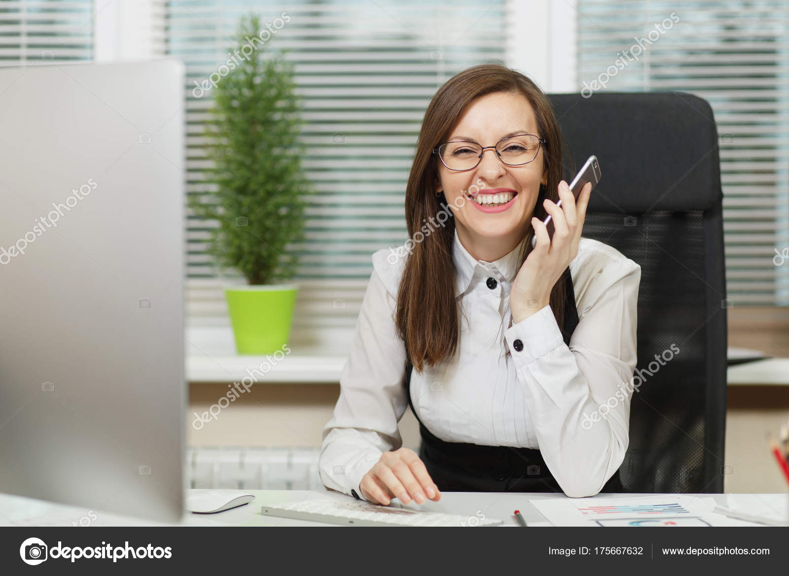 Beautiful smiling business woman in suit and glasses sitting at the ... Beautiful smiling business woman in suit and glasses sitting at the ...