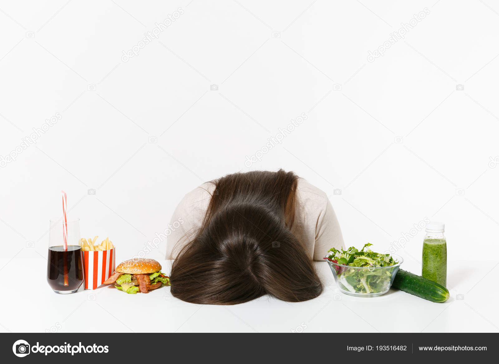 Woman put head on table with green detox smoothies, salad in glass bowl ...