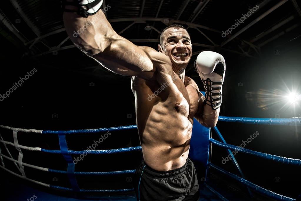 Punching boxer on boxing ring Stock Photo by ©tankist276 129099940