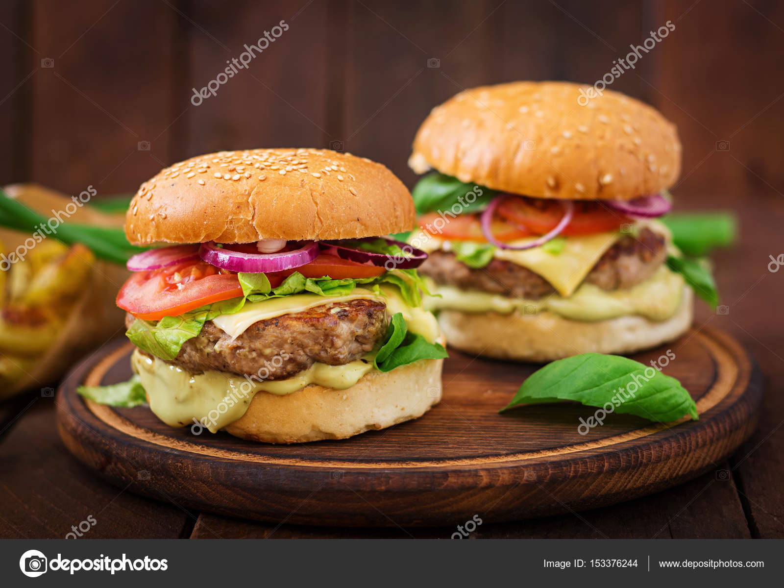 Two beef burgers on wooden plate Stock Photo by ©timolina 153376244