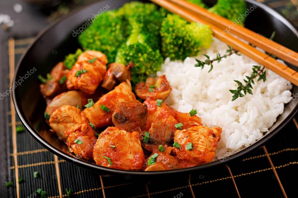 Trozos de filete de pollo con champiñones guisados en salsa de tomate y ...