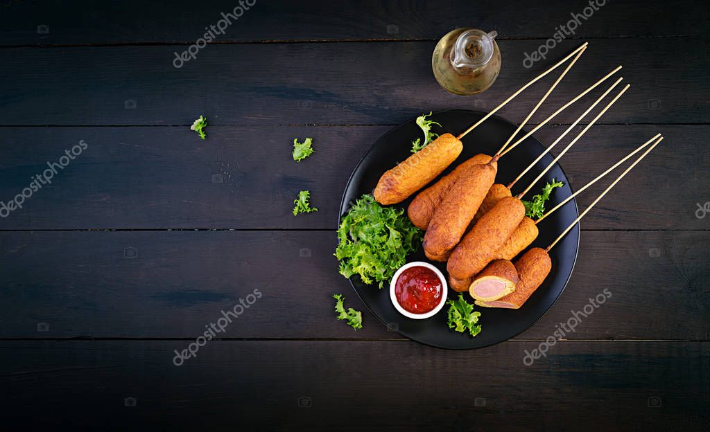 Perros de maíz americanos tradicionales con mostaza y ketchup en plato ...