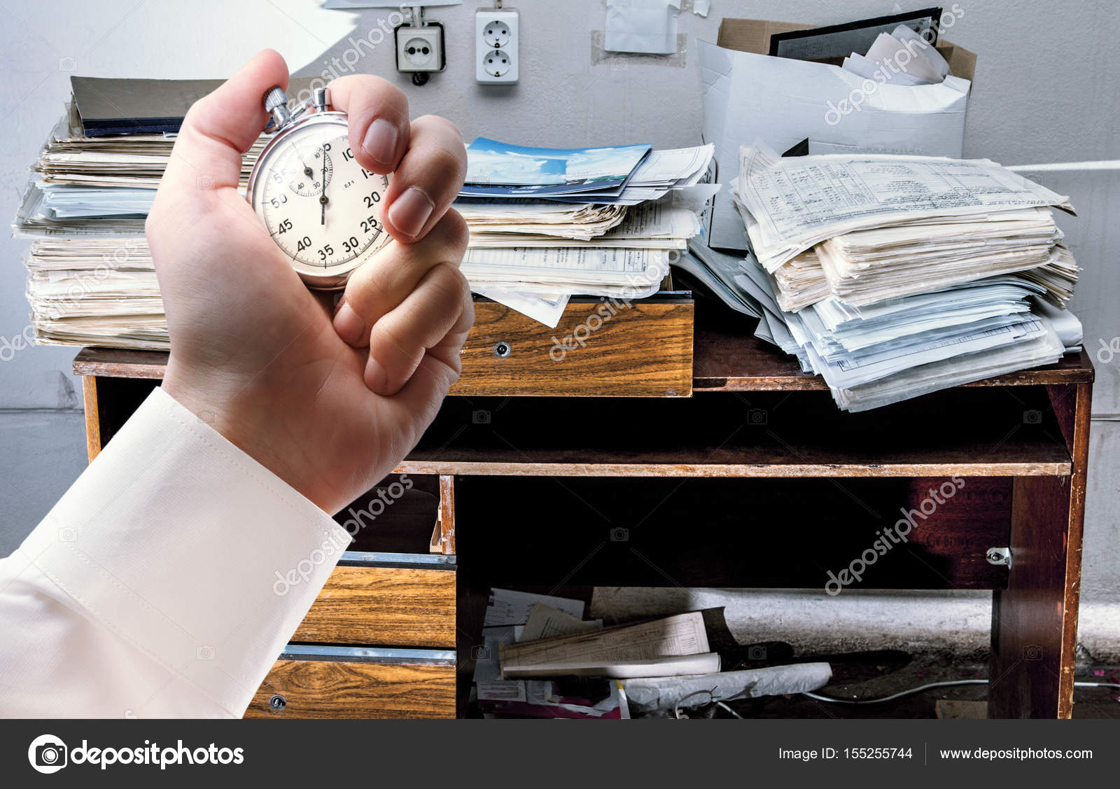 Messy workplace and stopwatch in hand Stock Photo by ©Garsya 155255744
