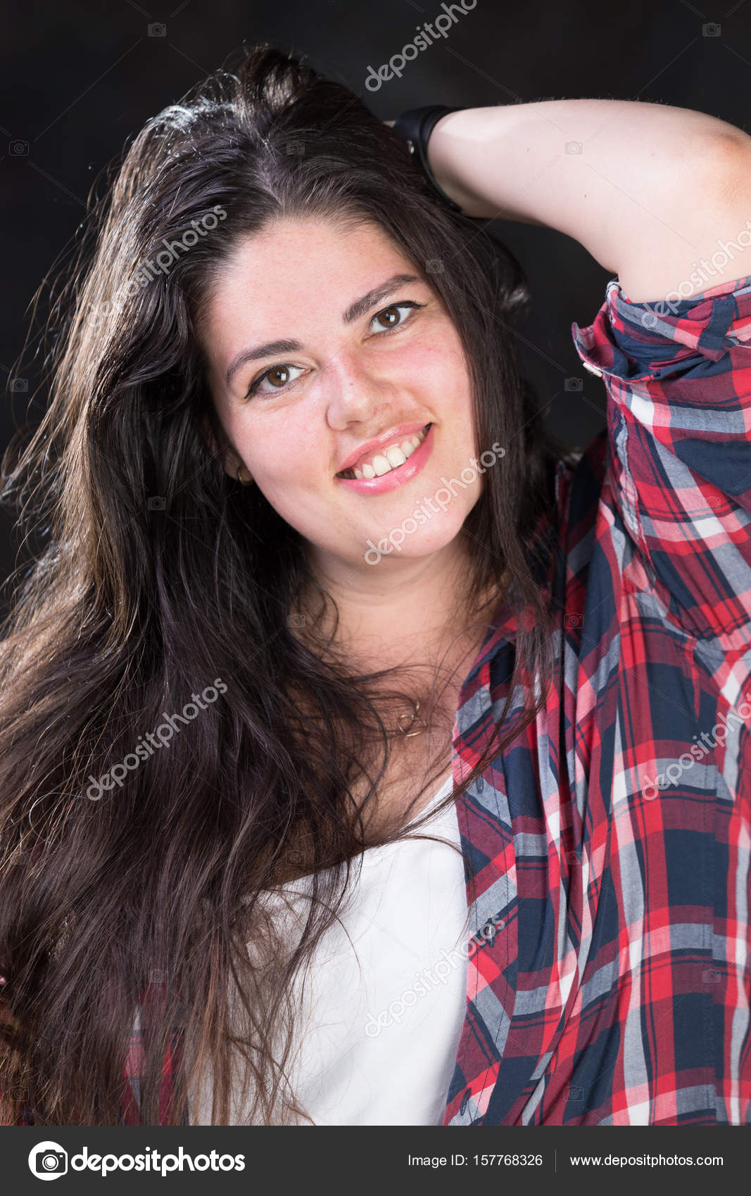 Beautiful plus size model with a dark long hair in a casual outfit ...