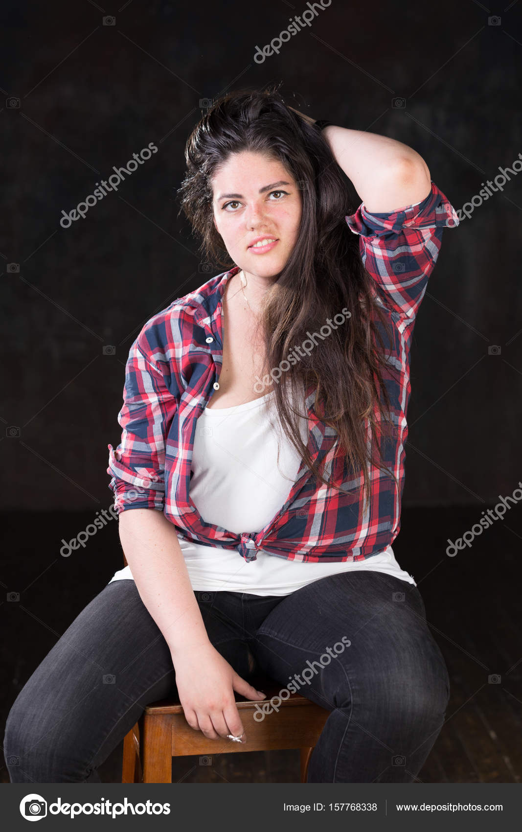 Beautiful plus size model with a dark long hair in a casual outfit ...