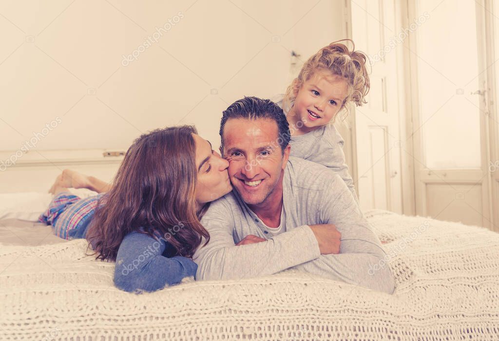 Retrato de estilo de vida de la hermosa familia feliz relajarse y pasar tiempo juntos en la cama ...