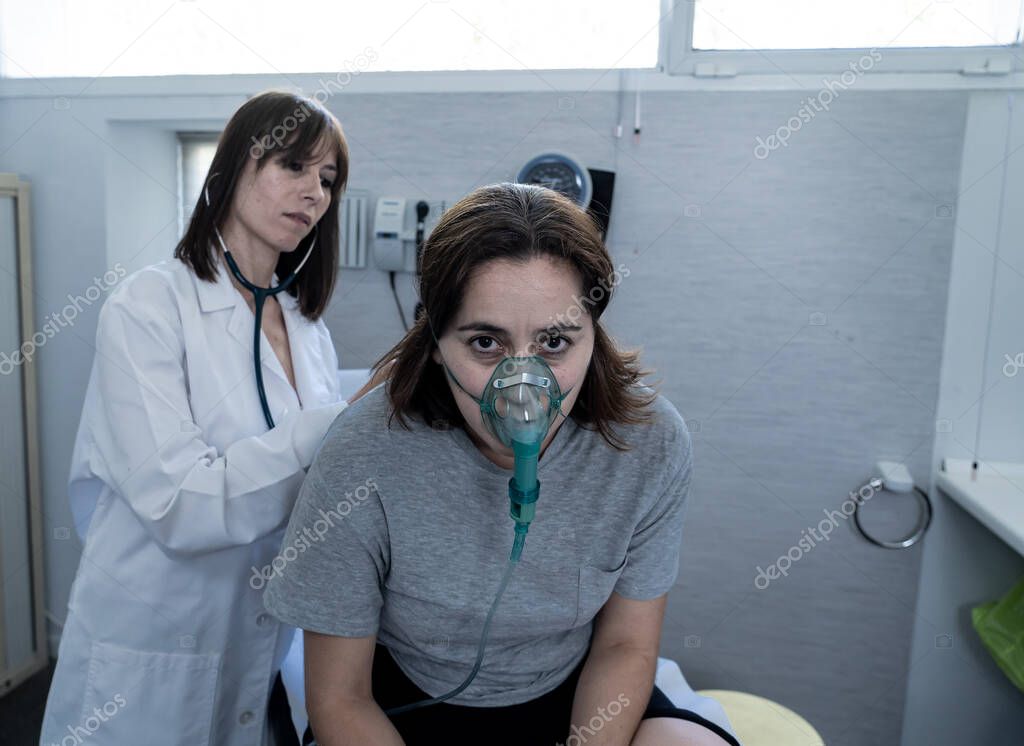 Mujer joven enferma con máscara de oxígeno mientras que la doctora ...