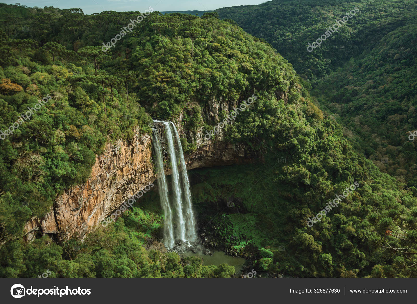 Waterfall falling from a cliff covered by forest Stock Photo by ...