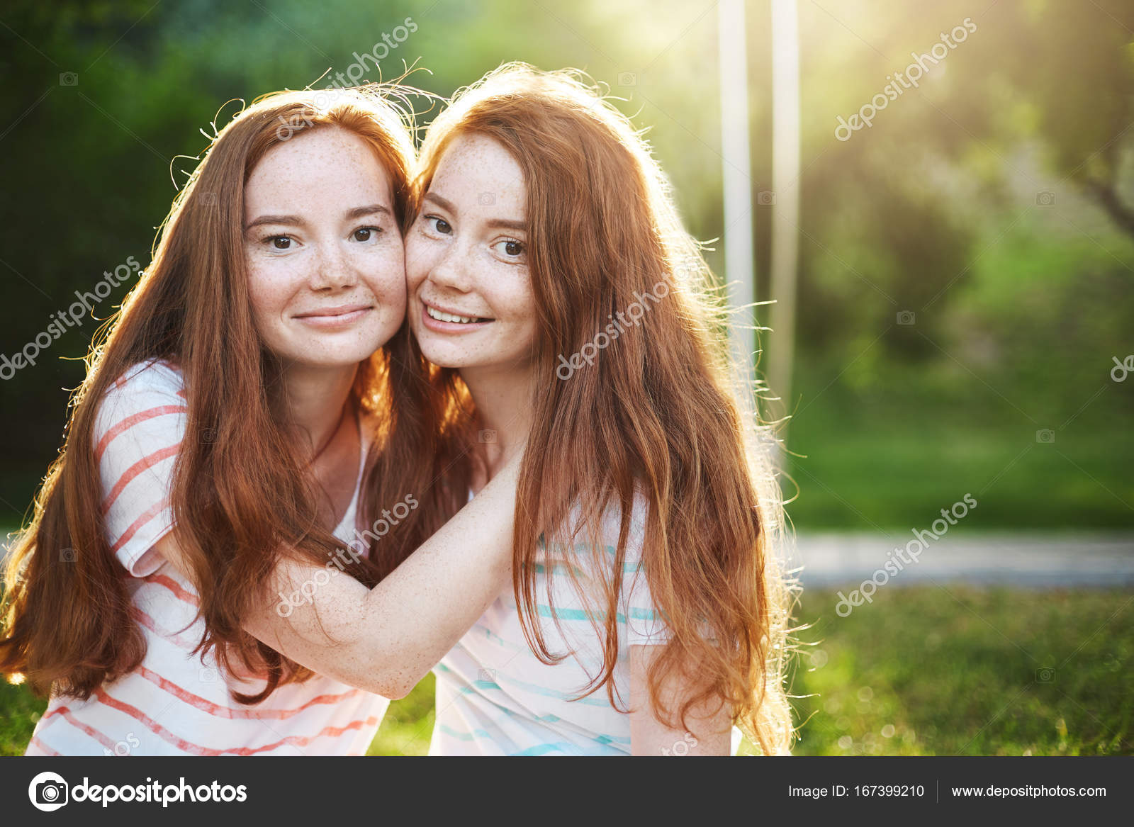 Twin ginger sisters are best friends forever. Young ladies looking at ...
