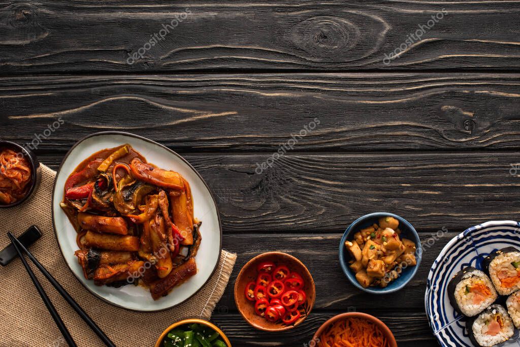 vista superior de topokki coreano cerca de kimbap, palillos ...