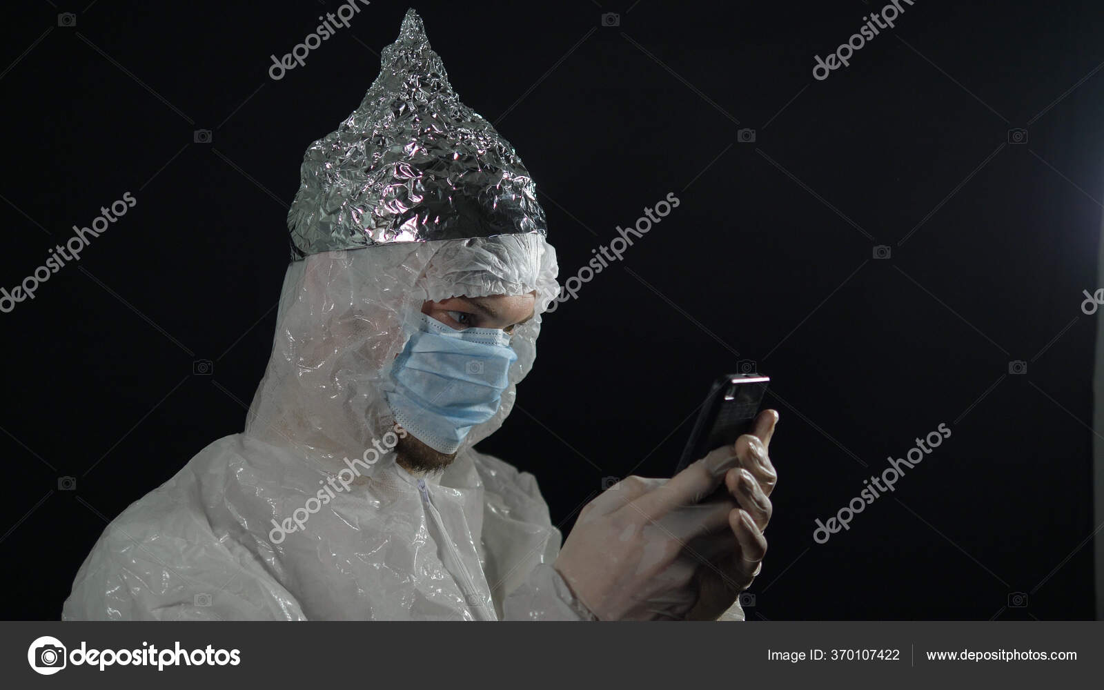5G towers radiation protection, a young man in a foil cap looks at a ...