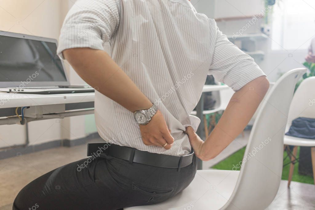 asiático hombre de negocios se siente dolor de espalda, sentado en la ...