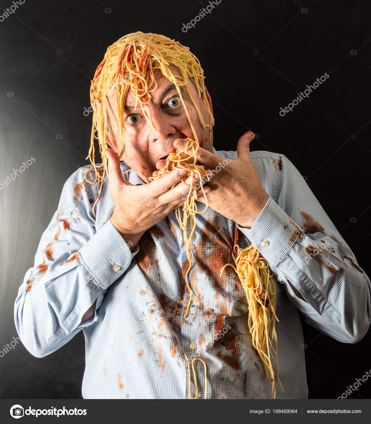 Man eating spaghetti with tomato sauce in head Stock Photo by ...