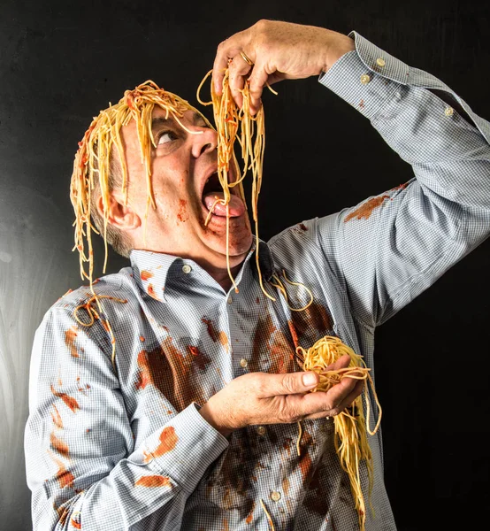 Man eating spaghetti with tomato sauce in head Stock Photo by ...