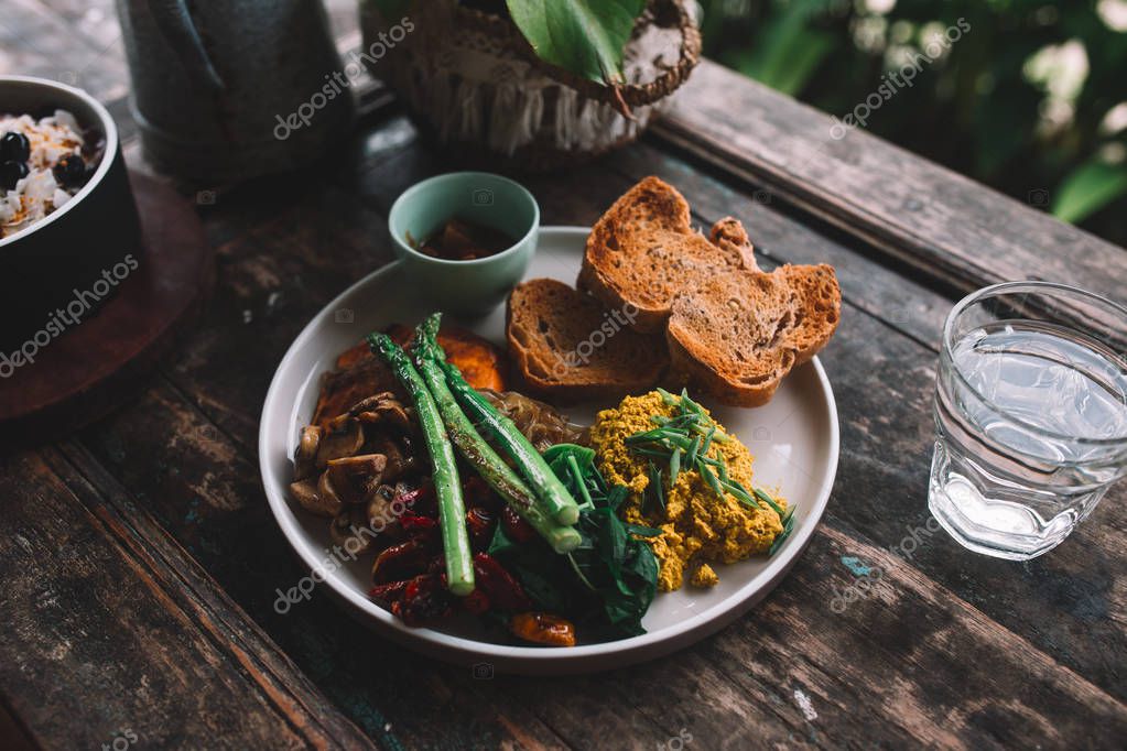 Placa con tortilla, pan, hierbas, champi ones y esp rragos en la mesa ...