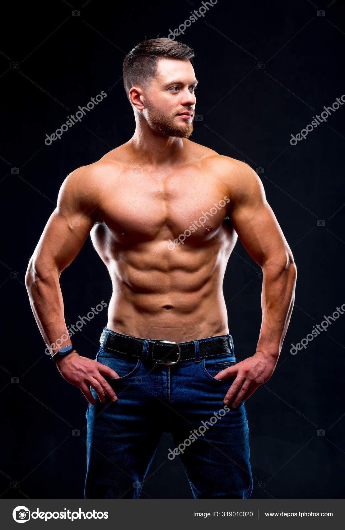 Handsome bodybuilder shirtless posing with hands on waist. Studio photo ...