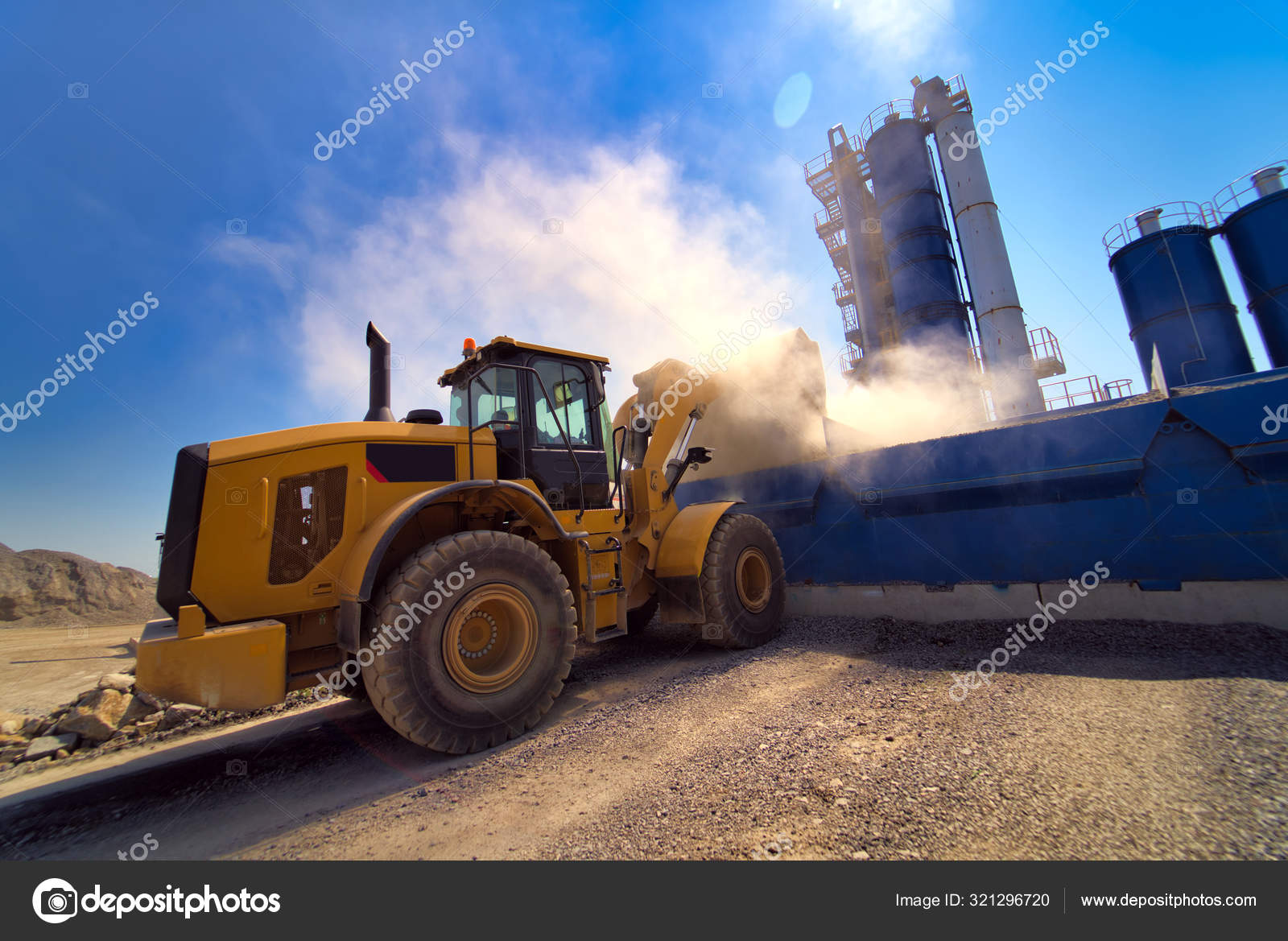 Orange wheel loader excavator in the background of a gravel storage in ...