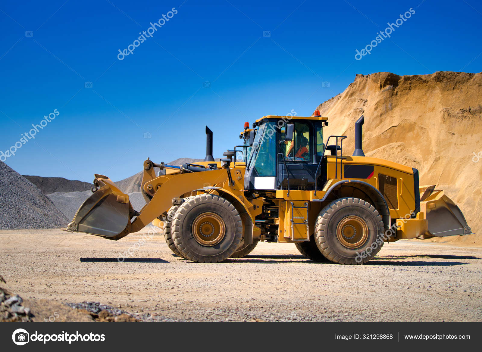 Yellow wheel skid-steer loader machine, loading gravel at construction ...