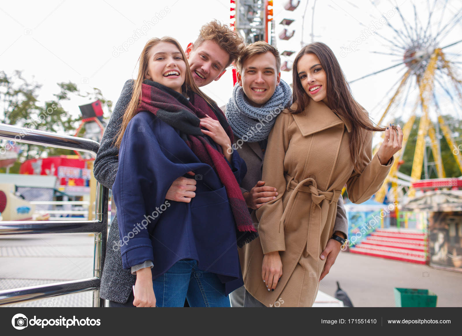 Beautiful young company having fun and laughing in the amusement park ...
