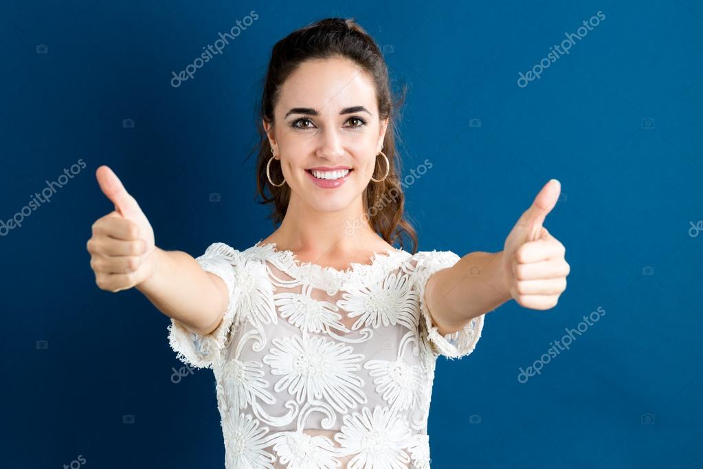 Young woman giving thumbs up — Stock Photo © Melpomene #126087584 Young woman giving thumbs up — Stock Photo © Melpomene #126087584