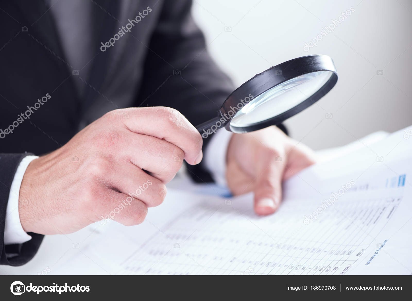 Businessman checking a tablet with magnifying glass — Stock Photo ...