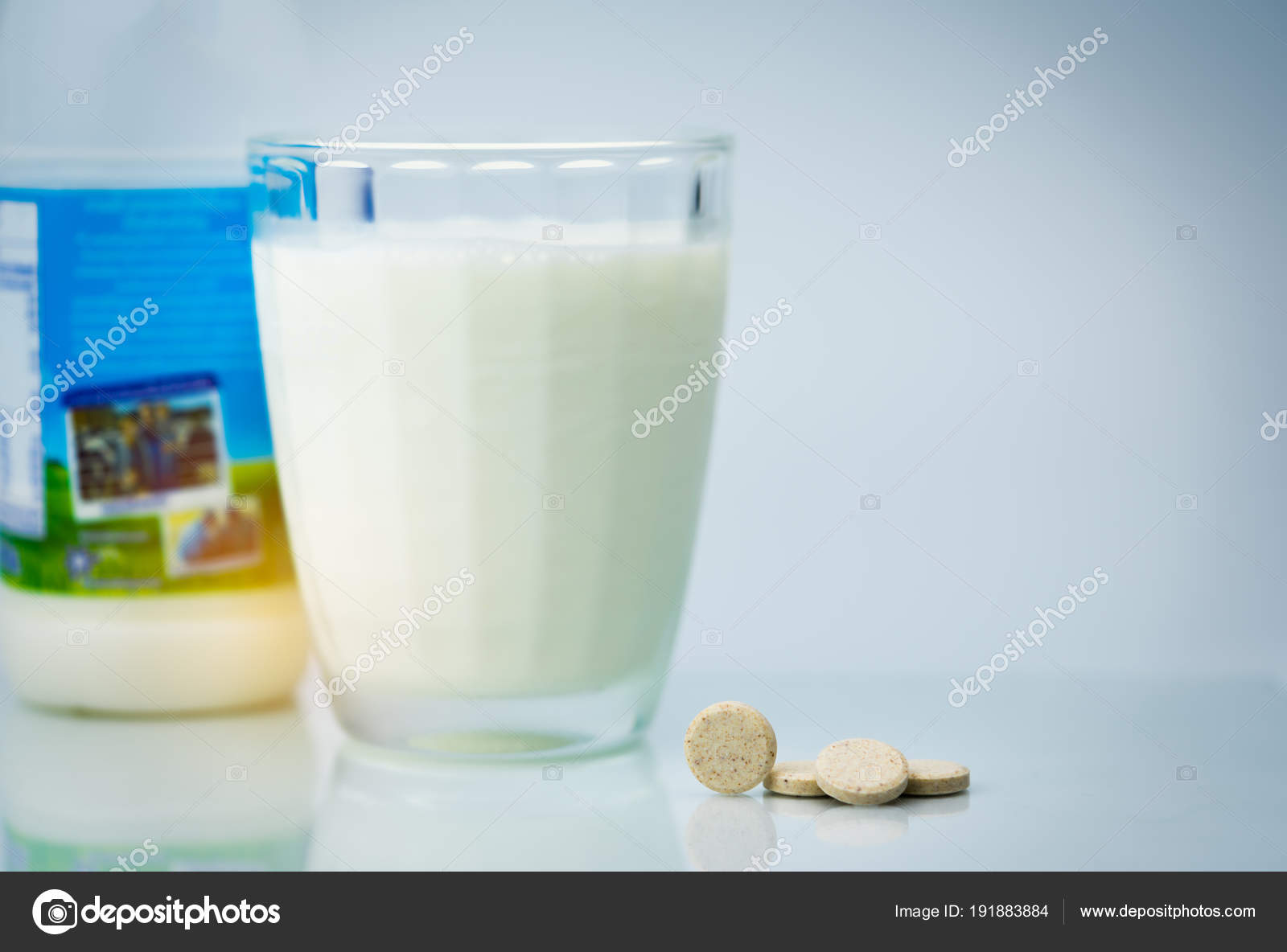 Sweetened flavored milk tablets and one glass of milk and milk bottle ...