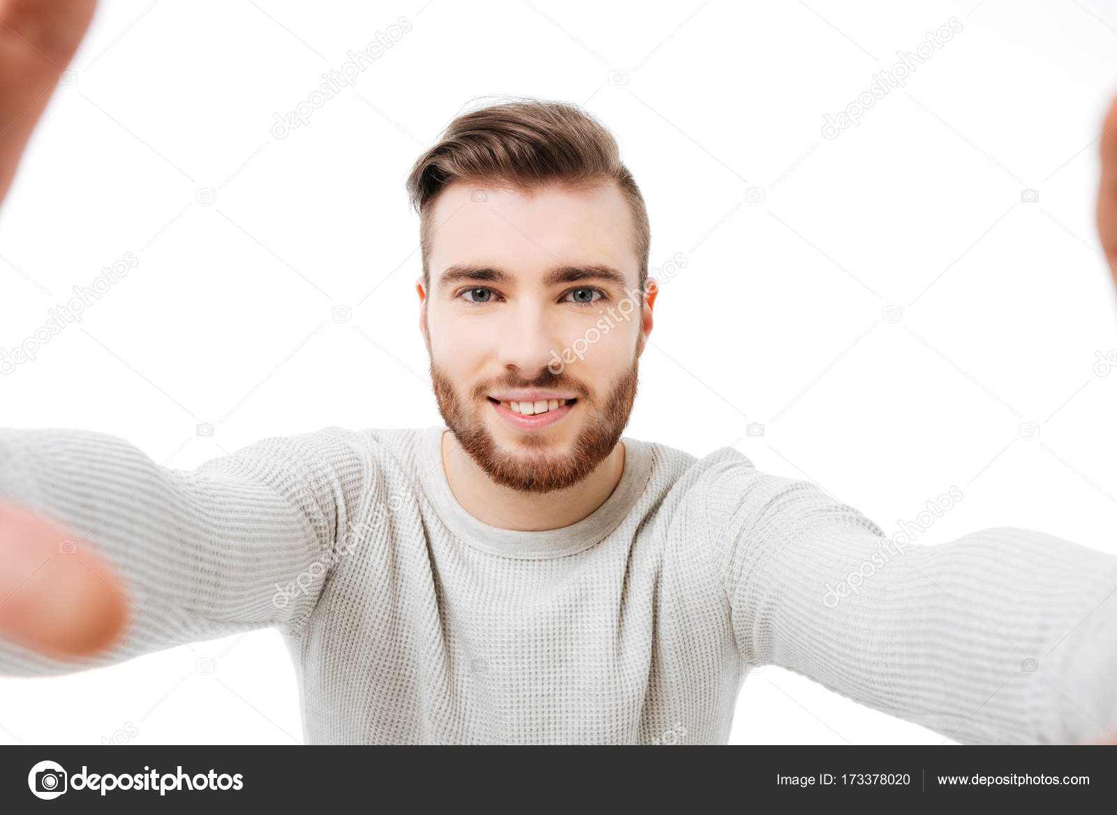 Young attractive man taking selfie over white background. Front camera ...