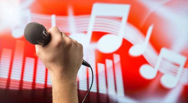 Man holding microphone in front of an abstract music and note ...