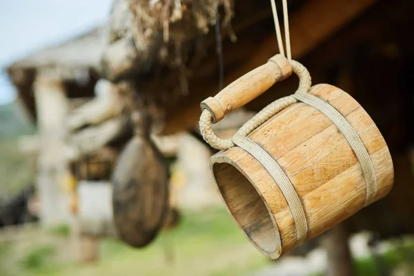 An old medieval wooden mug in the form of a historical reconstruction ...