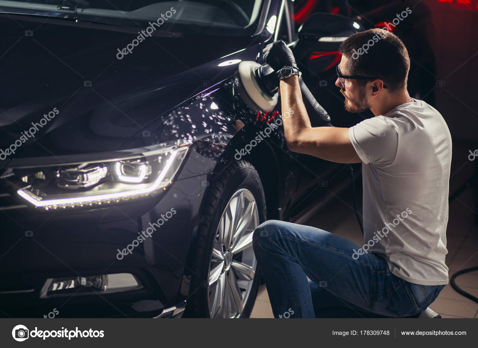 Car detailing - man with orbital polisher in auto repair shop ...