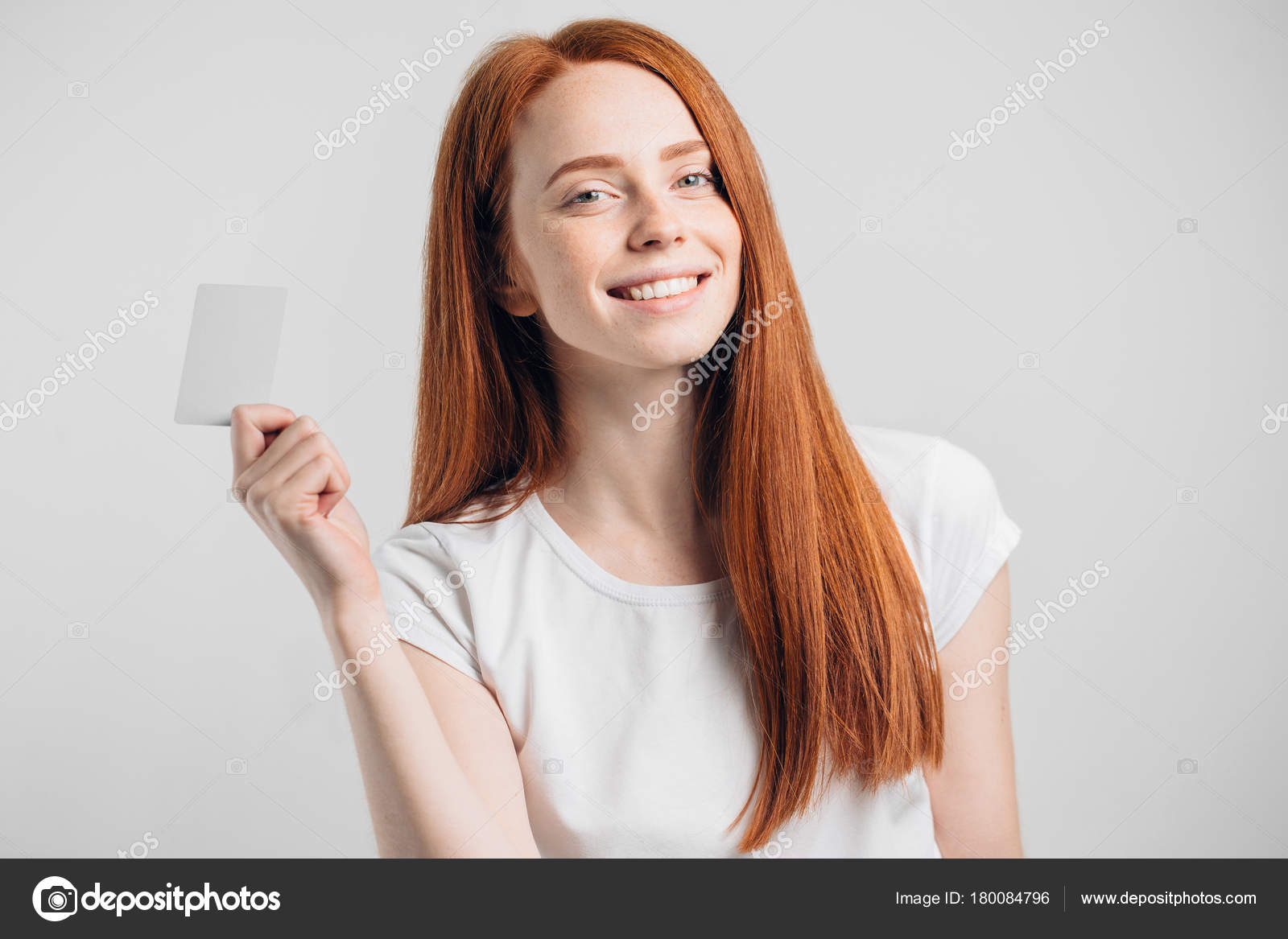 Redhead girl holding credit card and smiling on white background ... Redhead girl holding credit card and smiling on white background ...