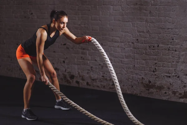 Woman training with battle rope in cross fit gym - Stock Image - Everypixel