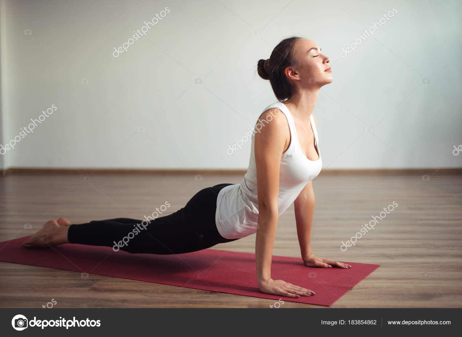 Woman practicing yoga indoor. Beautiful girl practice cobra asana in class — Stock Photo ...