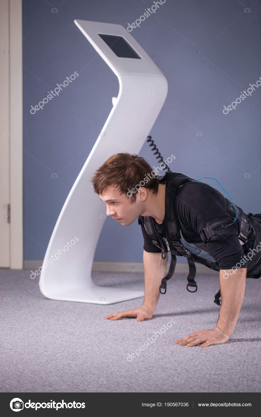 Man in Electrical Muscular Stimulation suits doing plank exercise. EMS ...