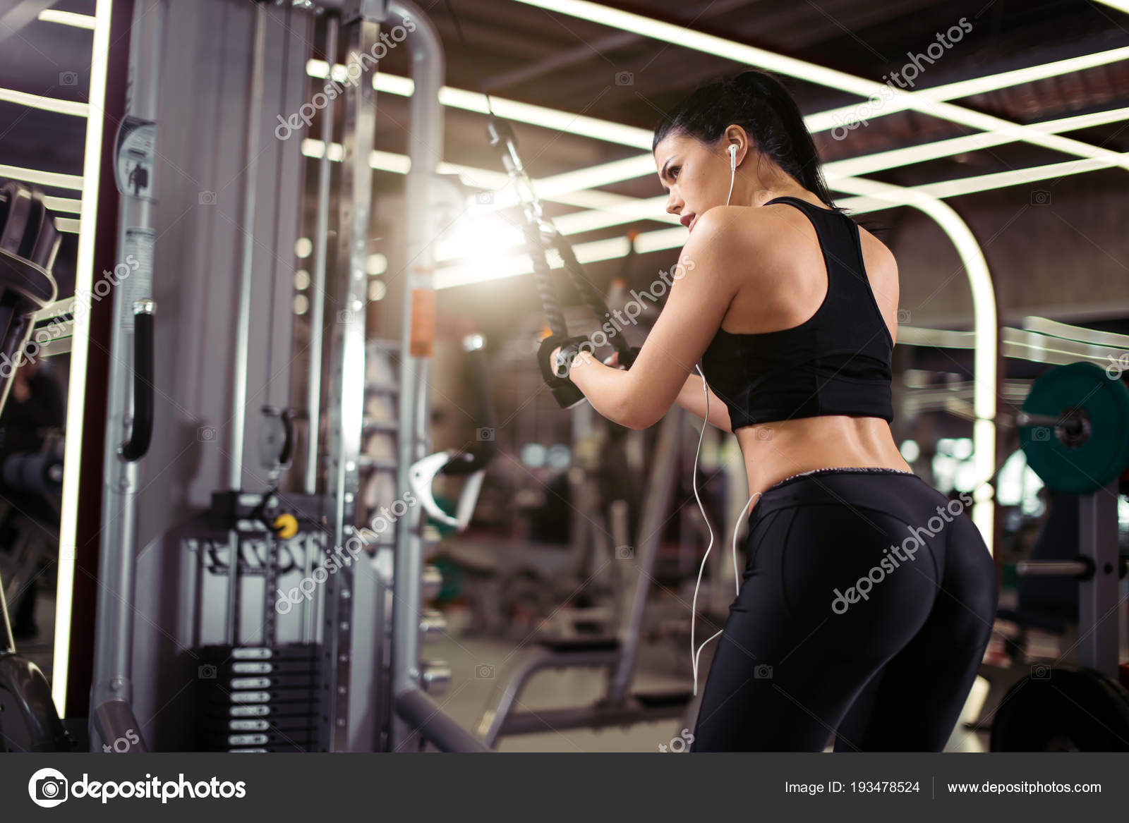 Rear view fit woman execute exercise with exercise-machine Cable ... Rear view fit woman execute exercise with exercise-machine Cable ...