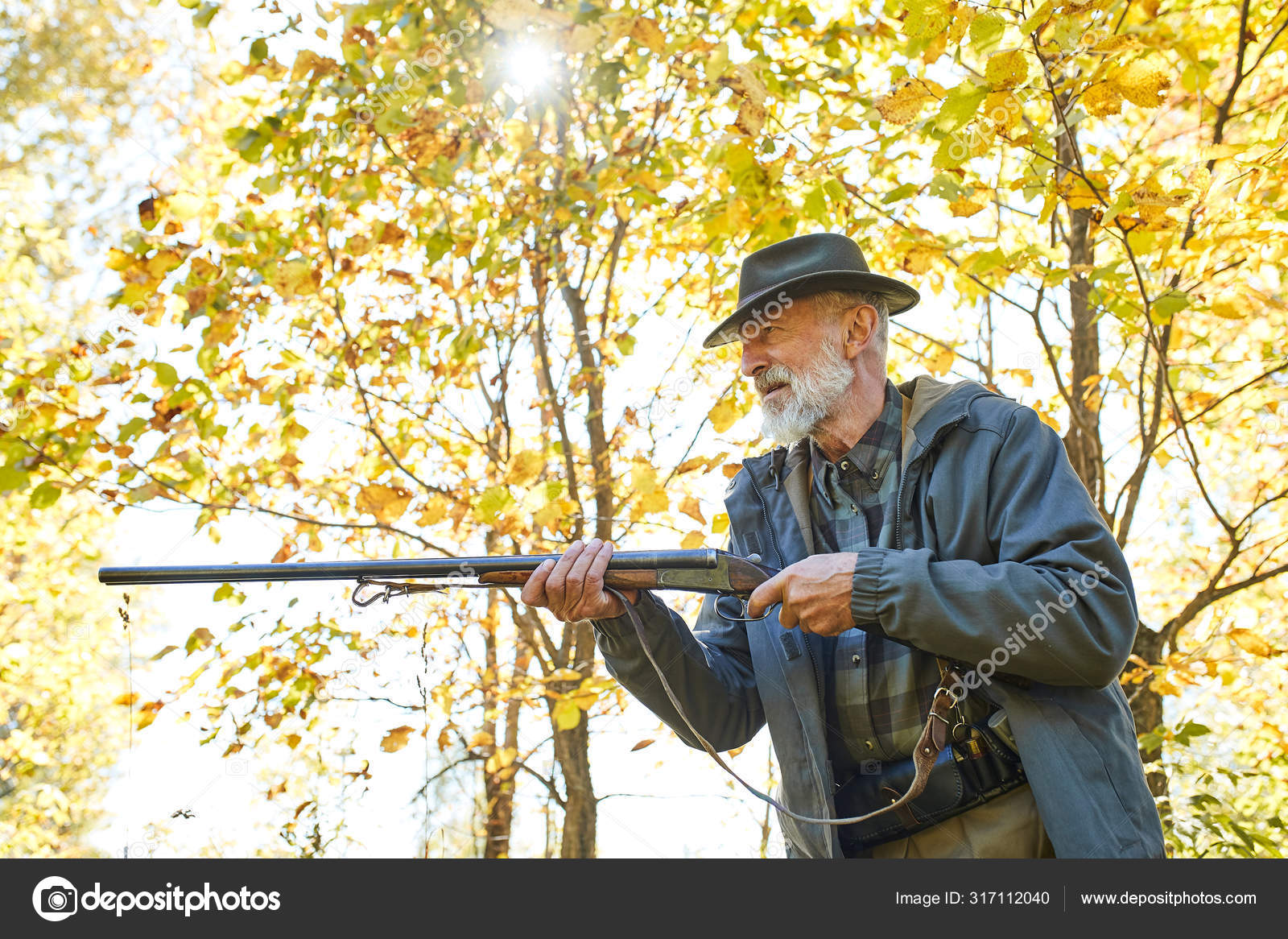 Senior hunter with his rifle in autumn forest — Stock Photo ...
