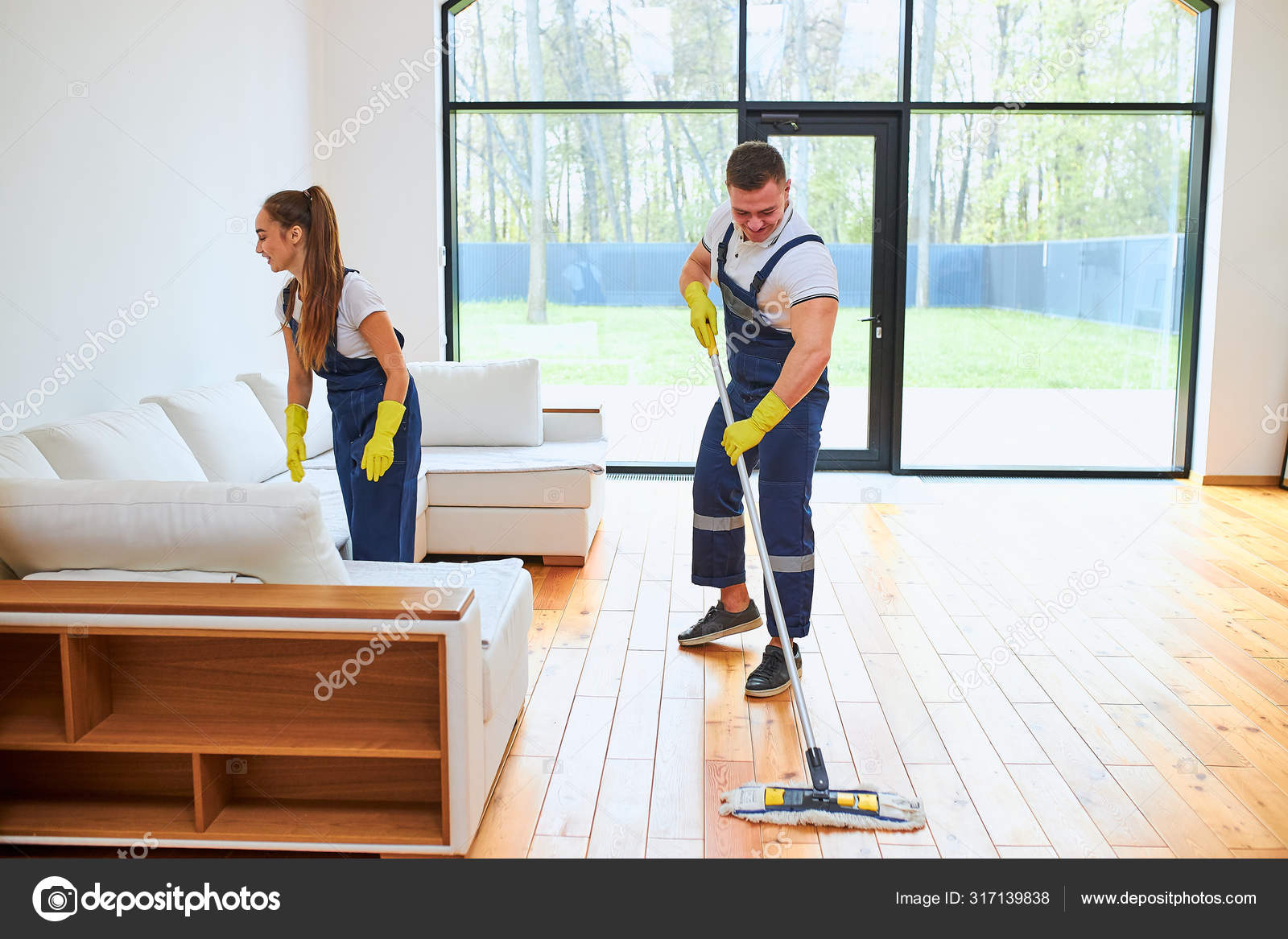 Two cleaners in uniform cleaning room with big window Stock Photo by ...