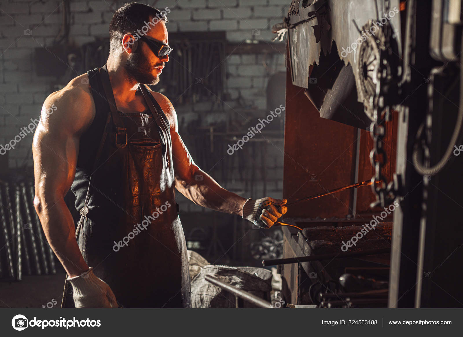 Serious brutal muscular blacksmith warming iron in furnace Stock Photo ...