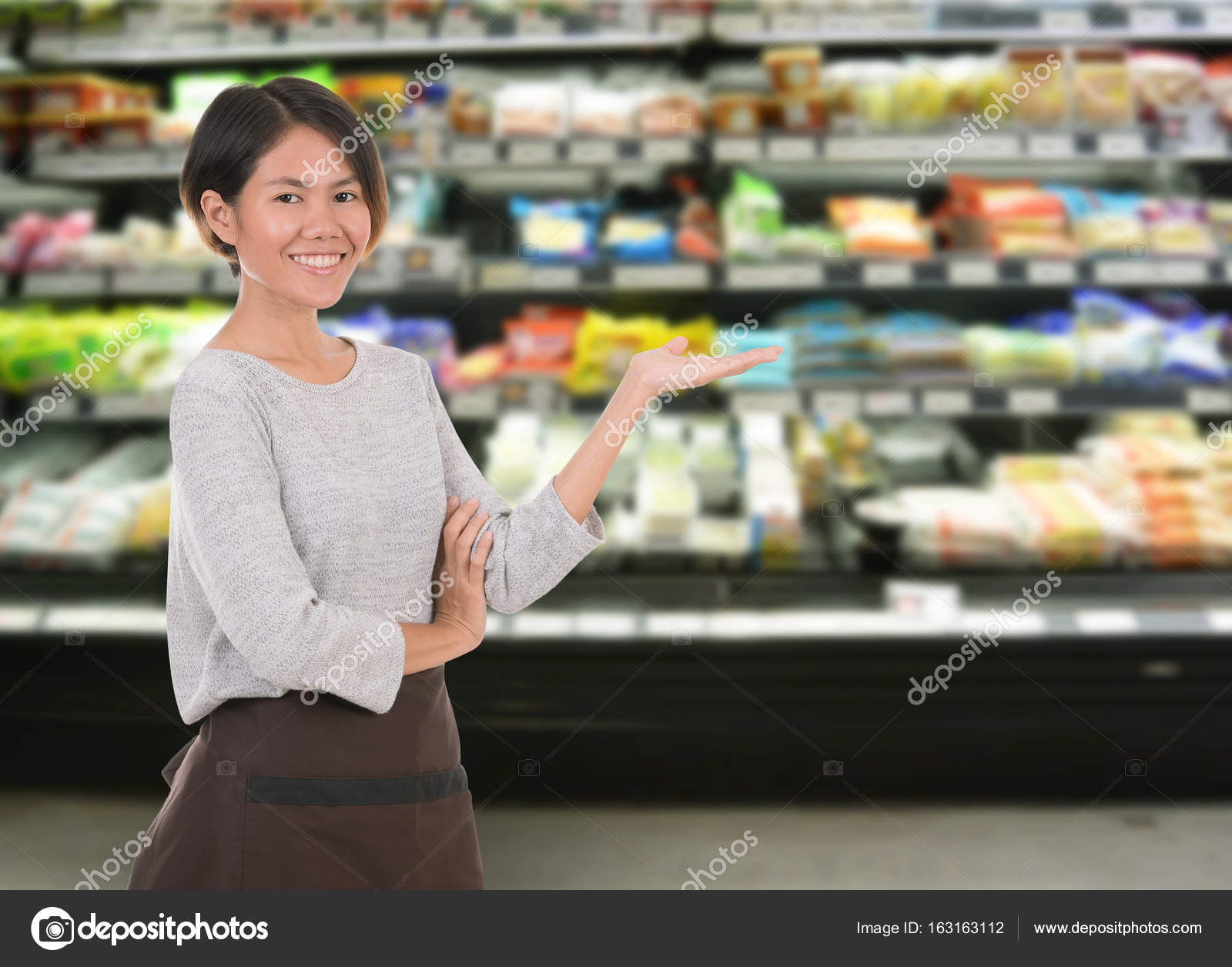 Smiling woman employee standing in supermarket shelf — Stock Photo ...