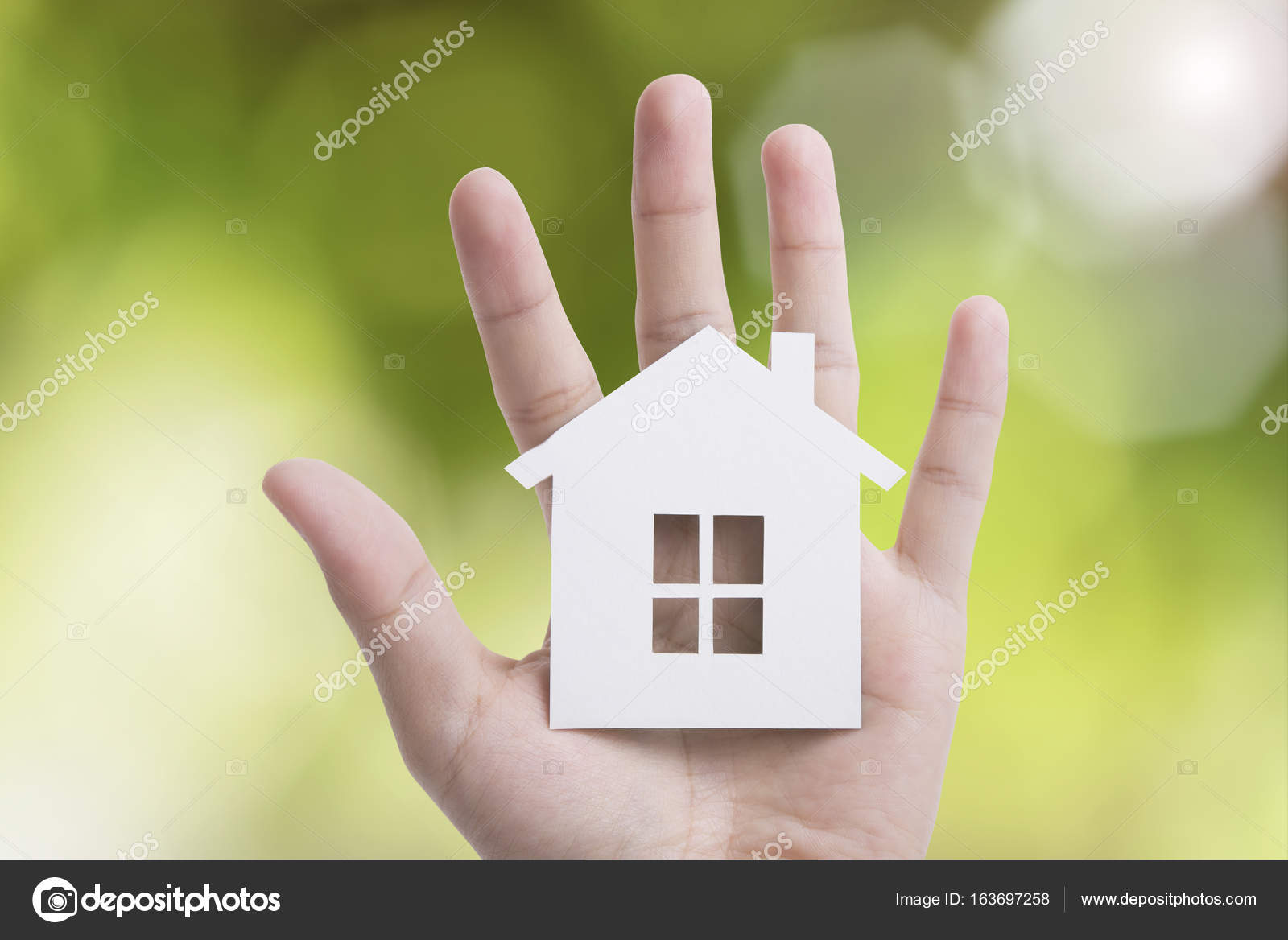 Hand holding home on green nature background. Stock Photo by ...