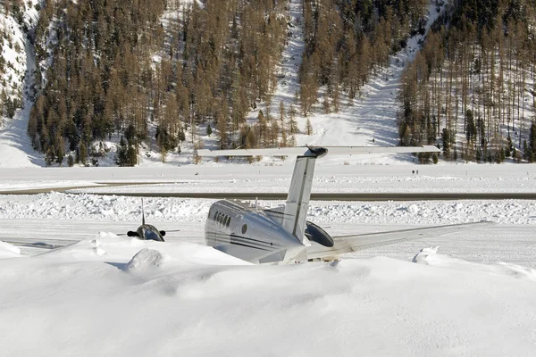 Rear view of a private jet in the snow covered airport in the alps ...