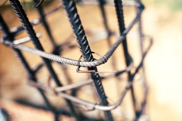 Details of construction worker - hands securing steel bars with wire ...